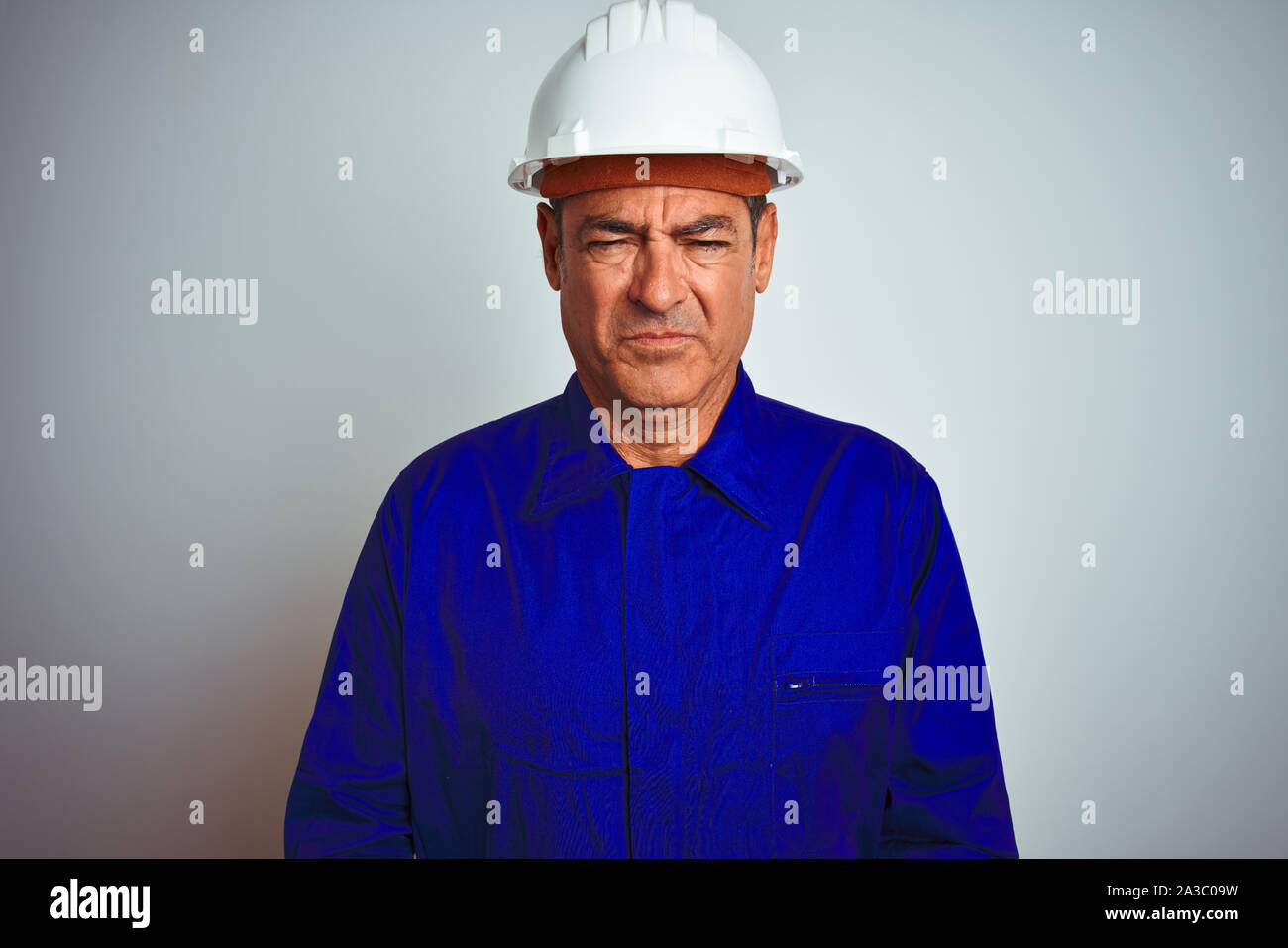 Handsome middle age worker man wearing uniform and helmet over isolated ...