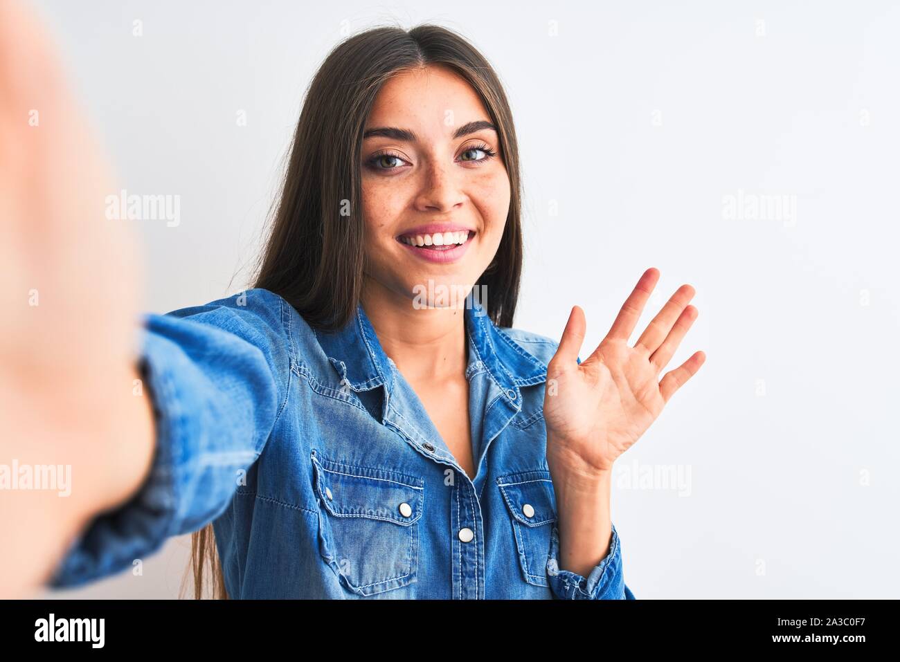 Beautiful woman wearing denim shirt make selfie by camera over isolated ...