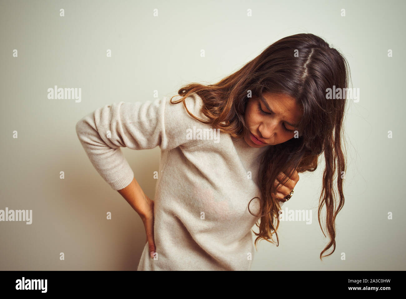 Young beautiful woman wearing winter sweater standing over white ...