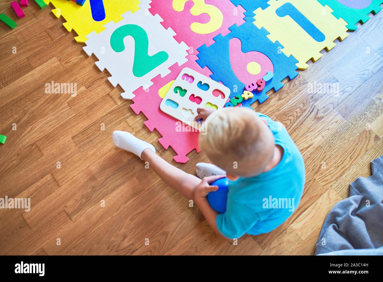 Young caucasian kid playing placing numbers at kindergarten ...