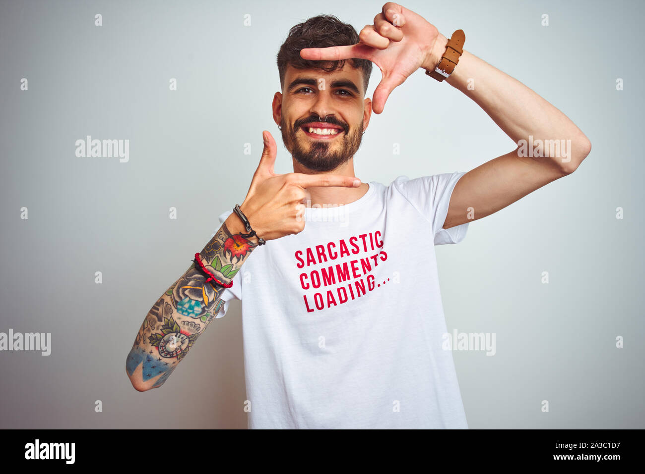 Young man with tattoo wearing fanny t-shirt standing over isolated ...
