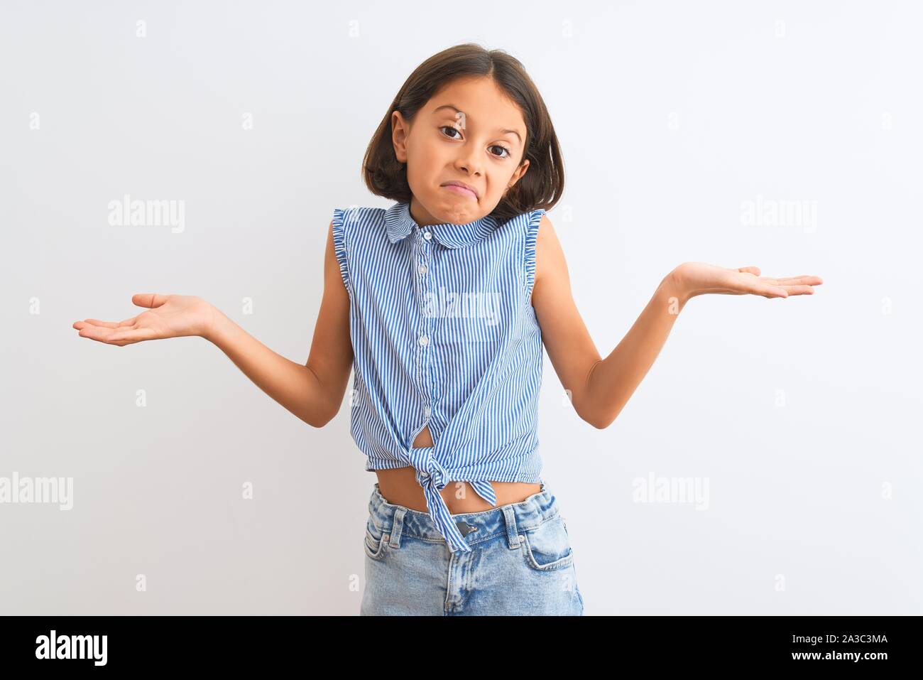 Young beautiful child girl wearing blue casual shirt standing over ...