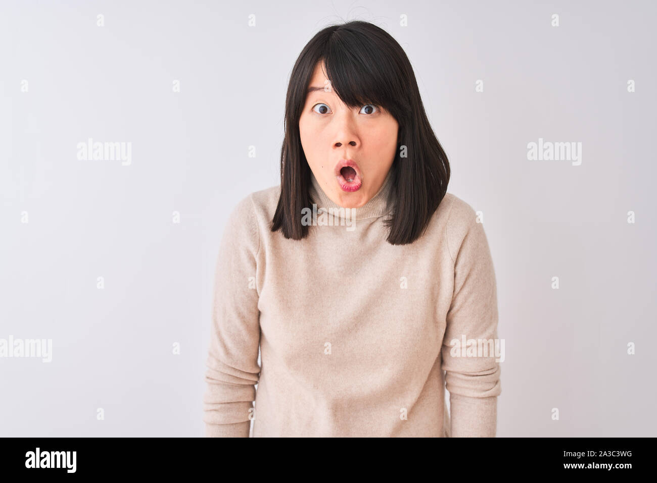 Young beautiful chinese woman wearing turtleneck sweater over isolated ...
