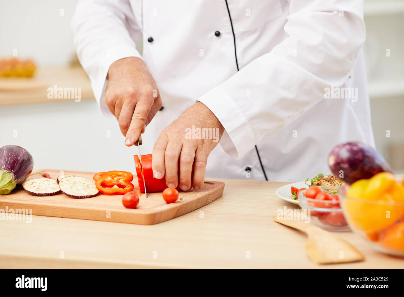 Close up of unrecognizable professional chef cutting vegetables while ...