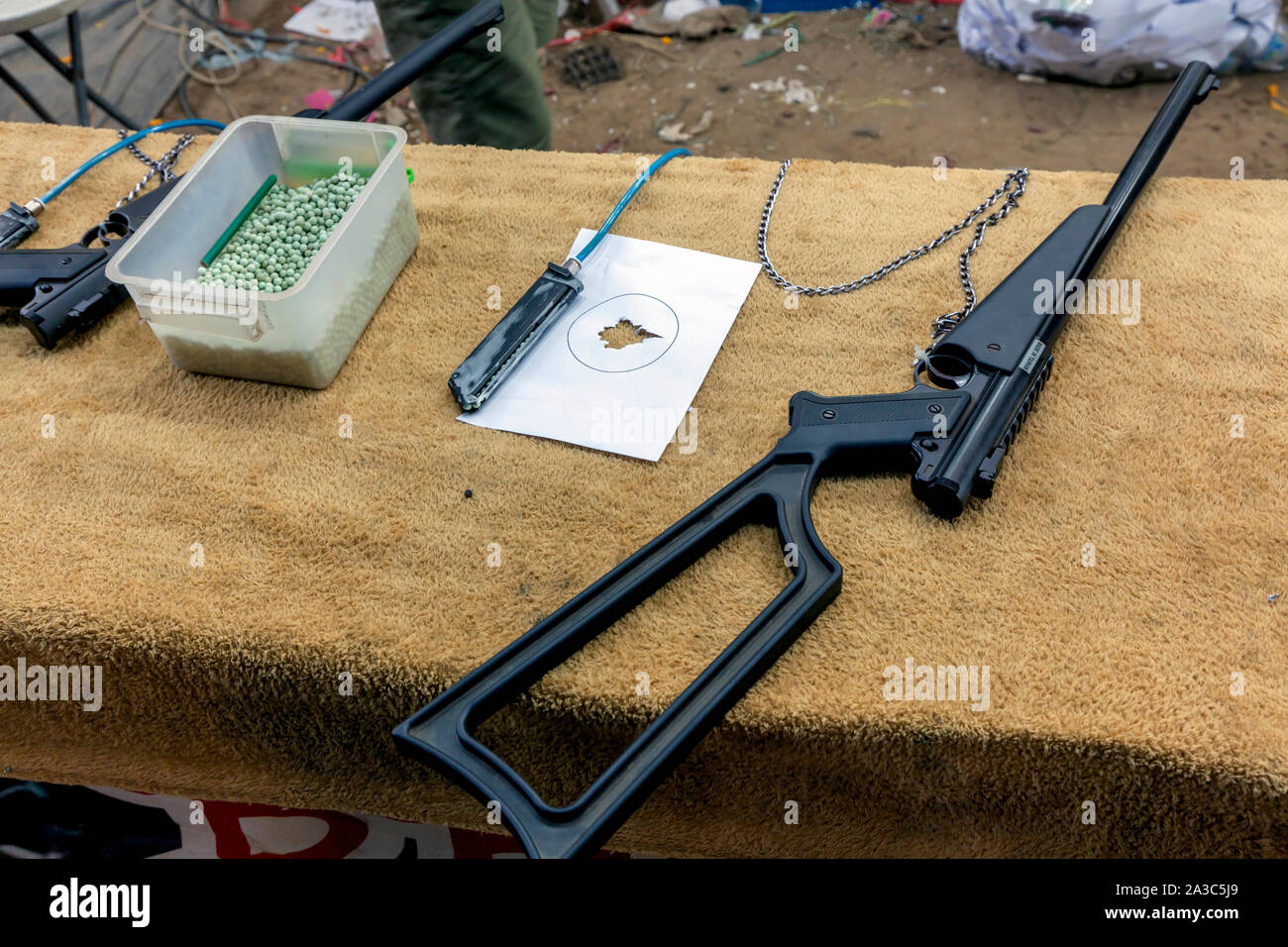 An air rifle that uses pellets for shooting at paper targets rests on a ...