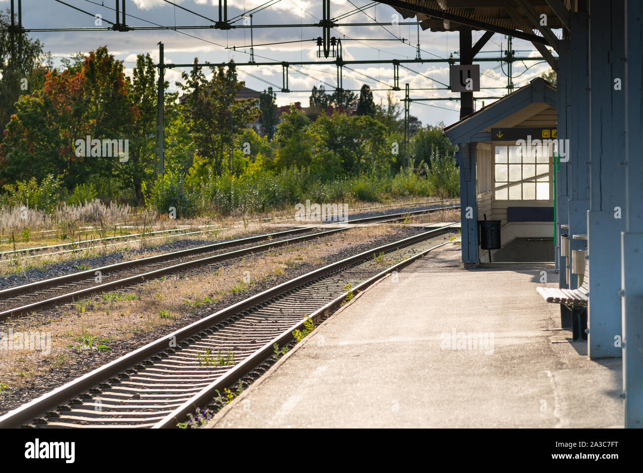 Empty platform with railway lines and station buildings with a view to ...