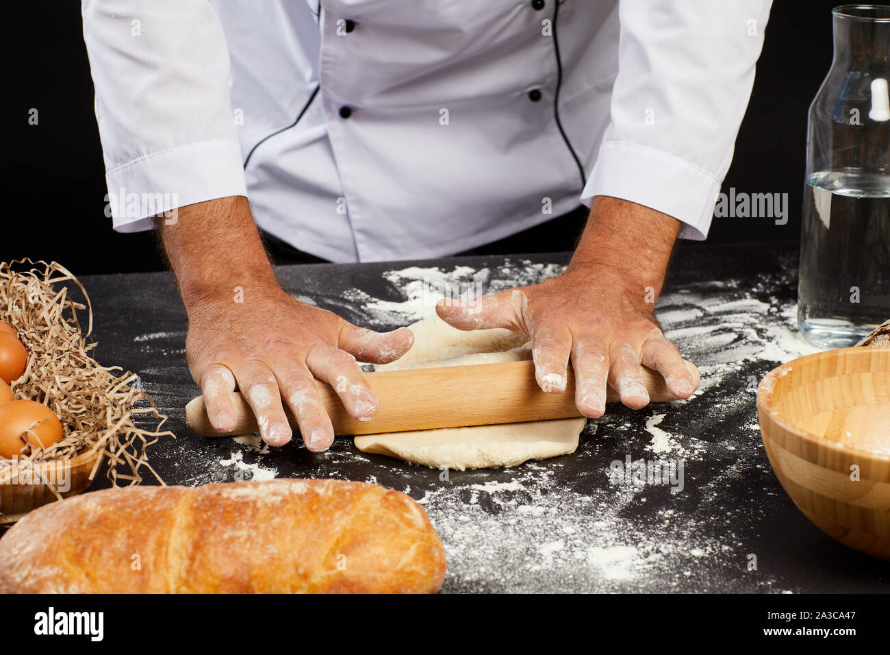 Close up of unrecognizable baker rolling batter while baking ...