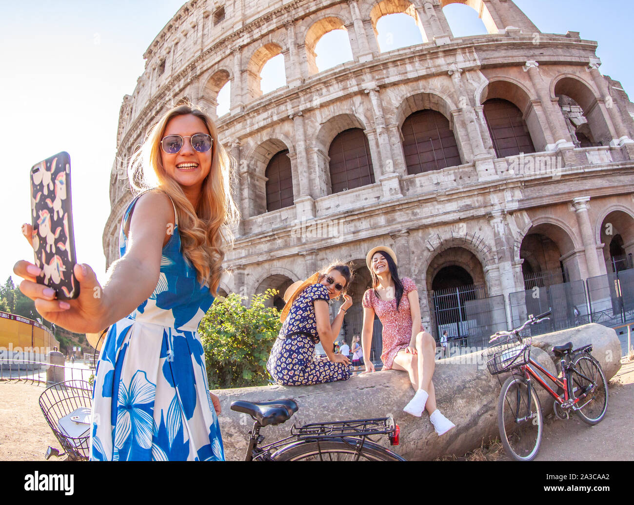 Three happy young women friends tourists taking selfies sitting at ...
