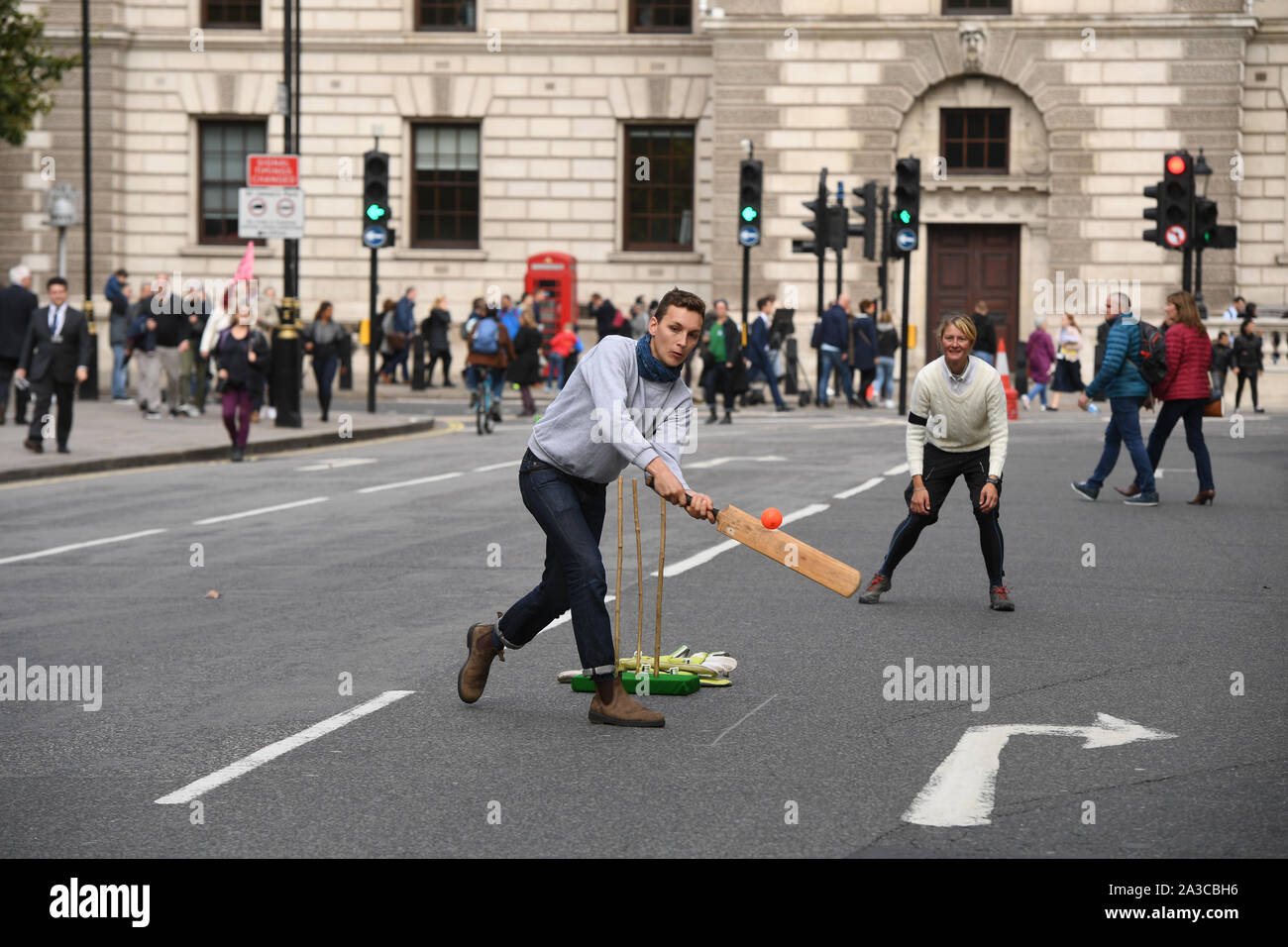 Demonstrators play a game of cricket during an Extinction Rebellion ...