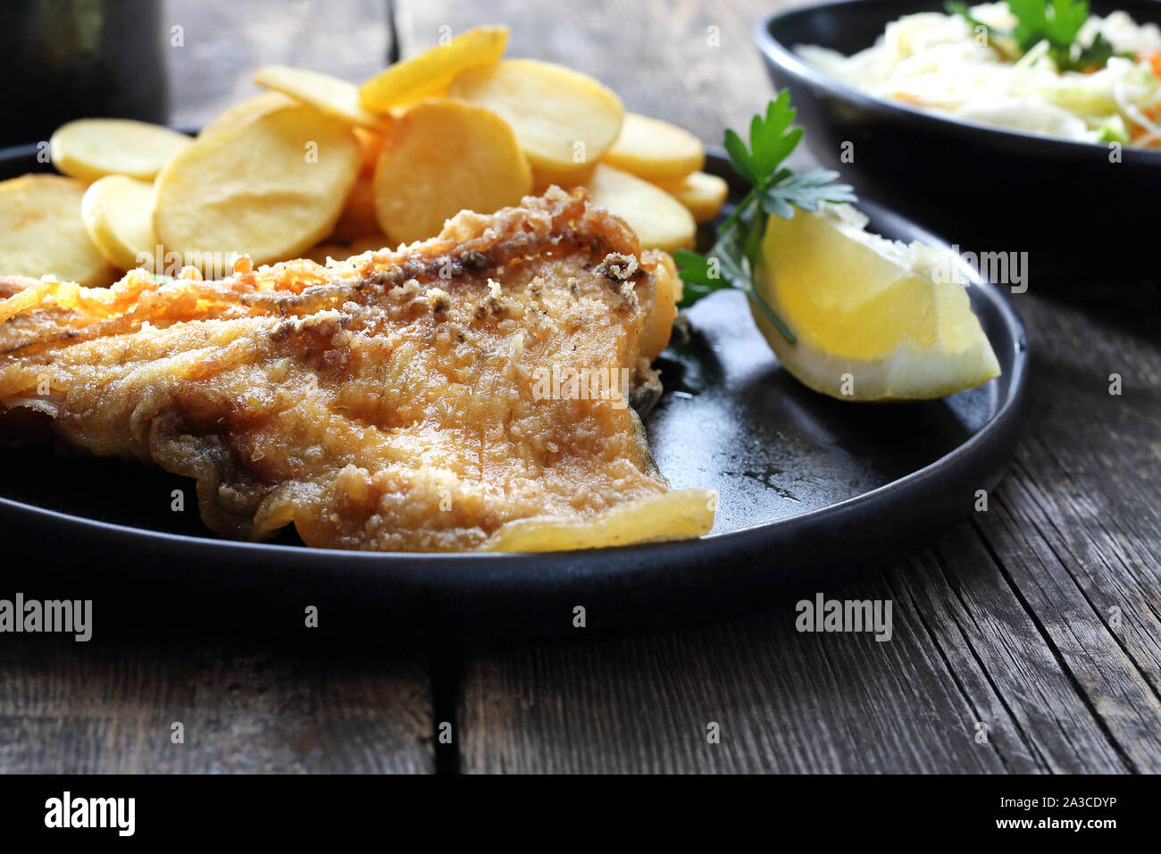 Fried fish fillet with baked potato slices Stock Photo - Alamy