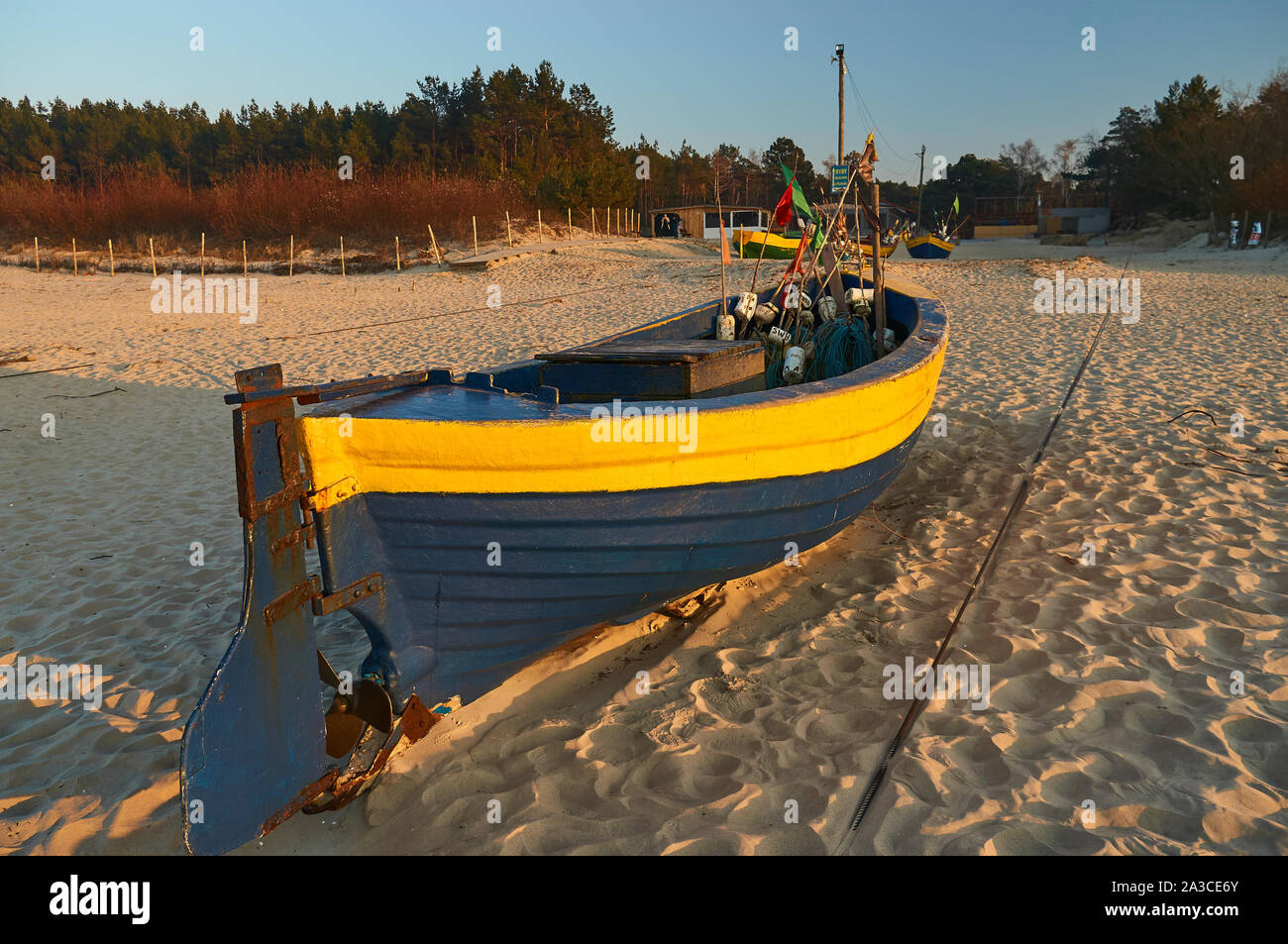Traditional Polish fishing boat (Kuter) during a sunset on a beach near ...