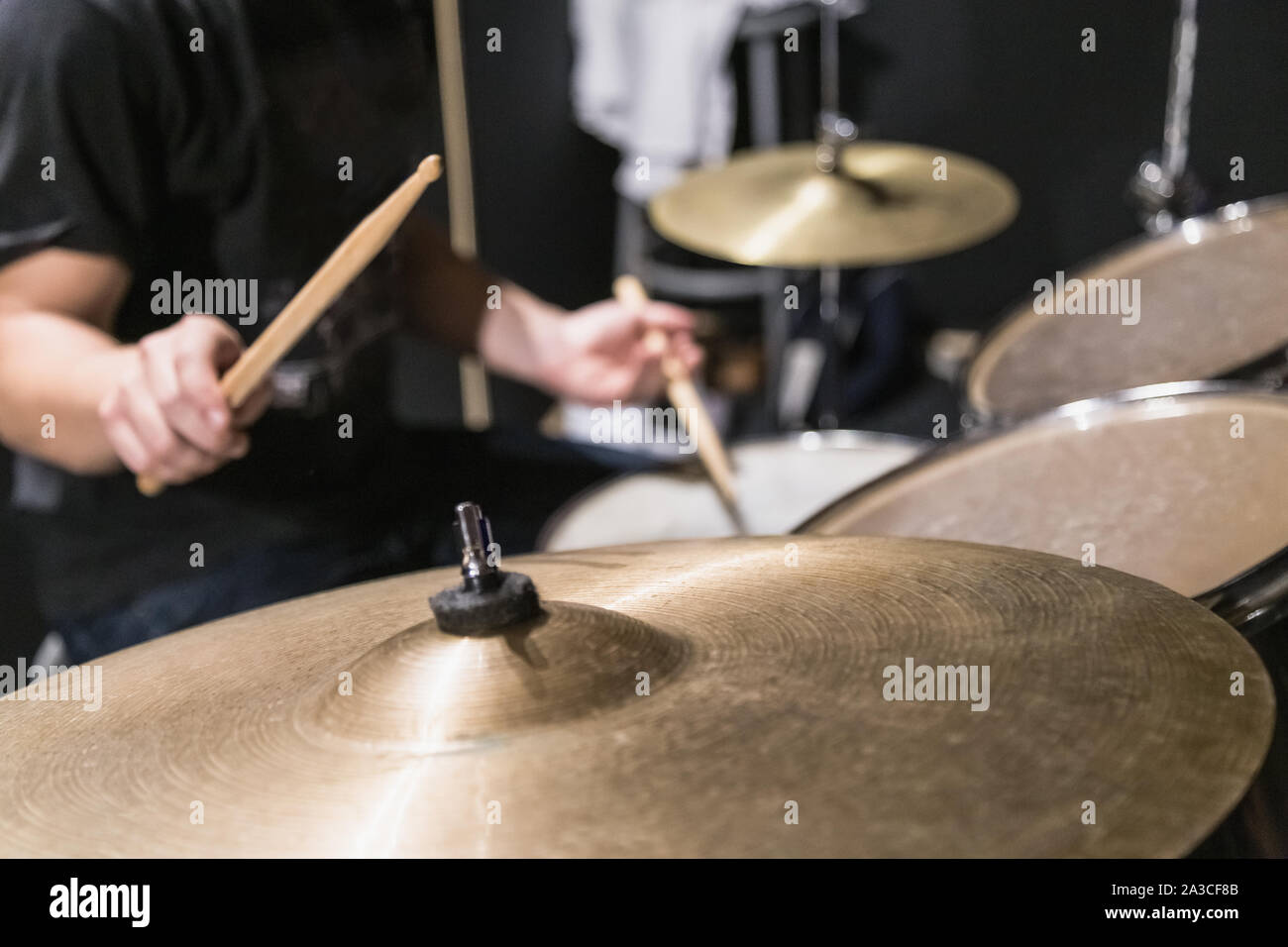 Close up of hands of male drummer holdning drumsticks sitting and ...