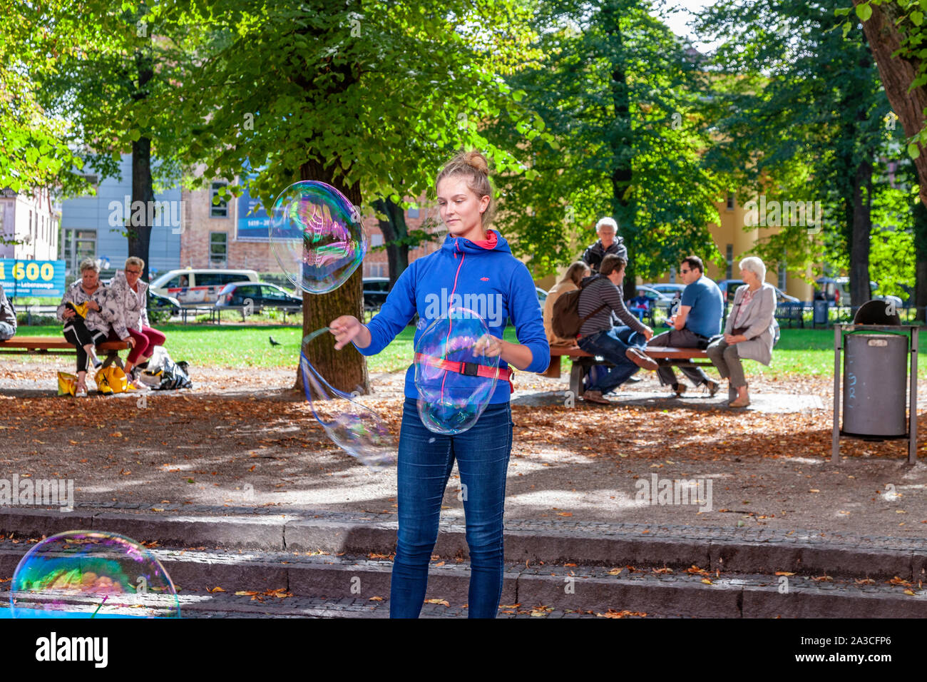 A female street performer on Kröpeliner street a busy shopping area in ...