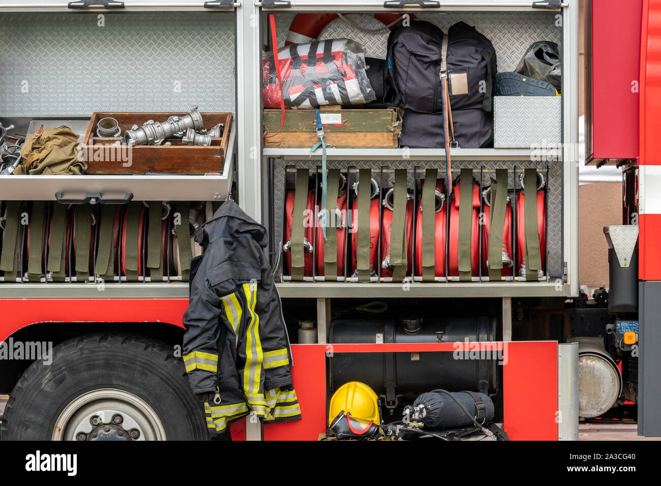 Side view of red municipal fire engine standing idle. Many equipment ...