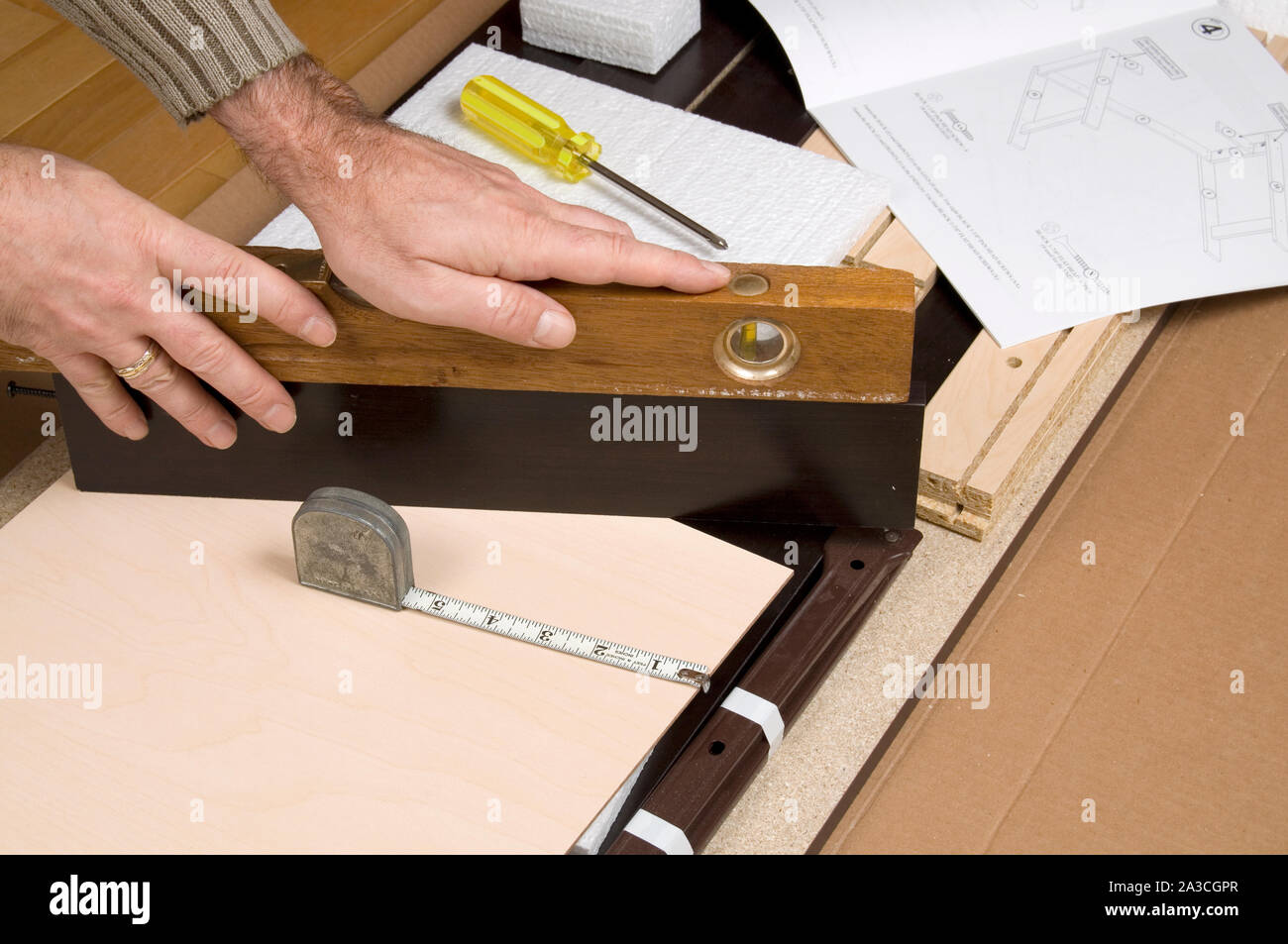 Person Assembling Furniture using a Level and a Screwdriver Stock Photo ...