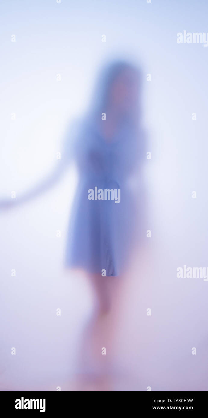 Blurred photo girl wearing dress dancing behind glass Stock Photo - Alamy