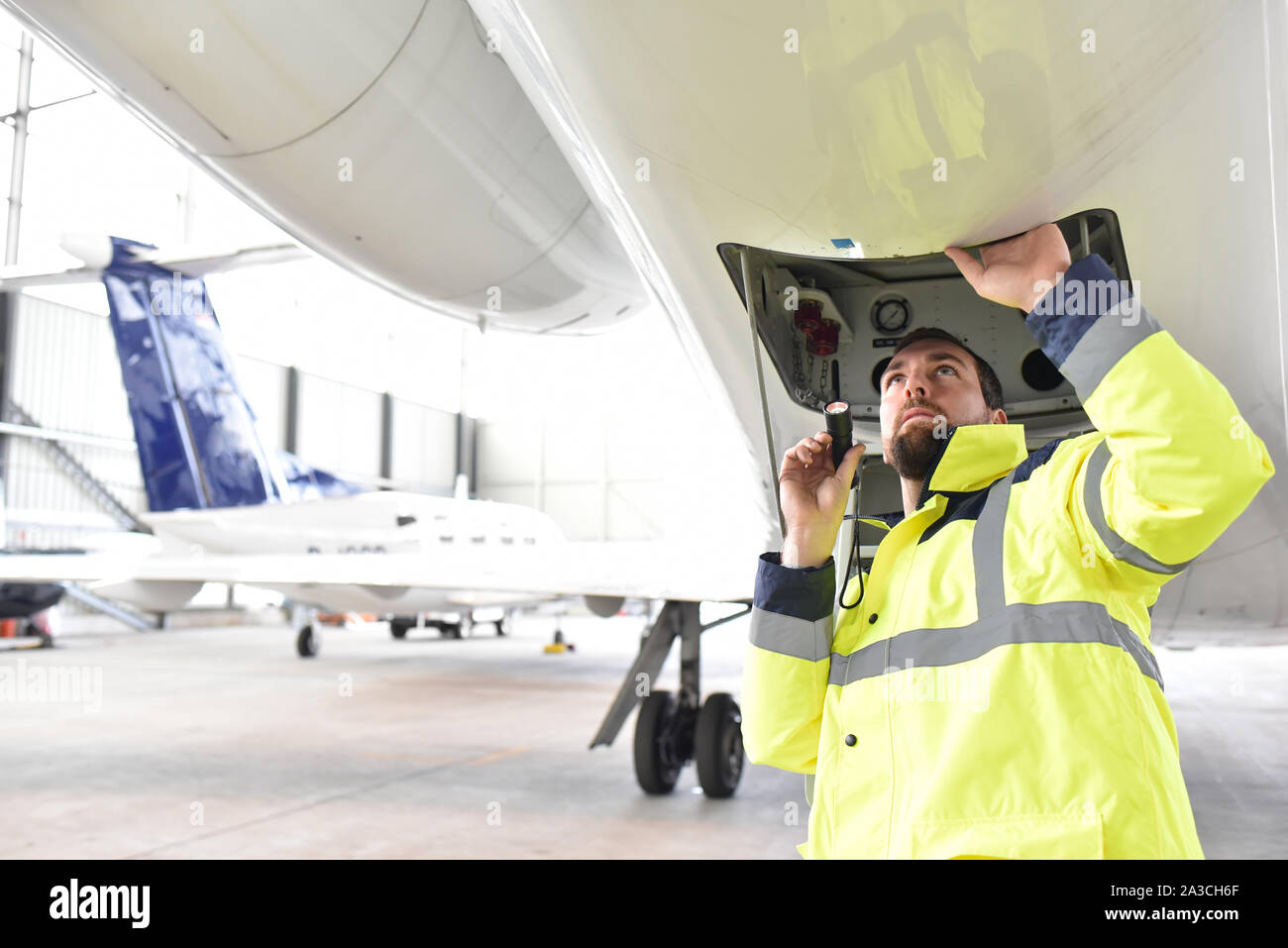 Airport workers check an aircraft for safety in a hangar Stock Photo ...