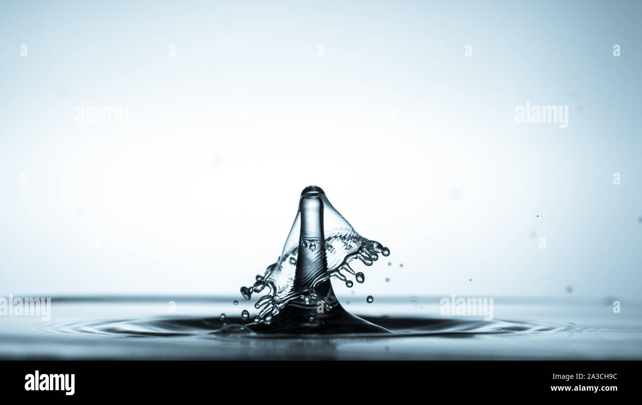 Close-up of a water drop falling on water surface Stock Photo - Alamy