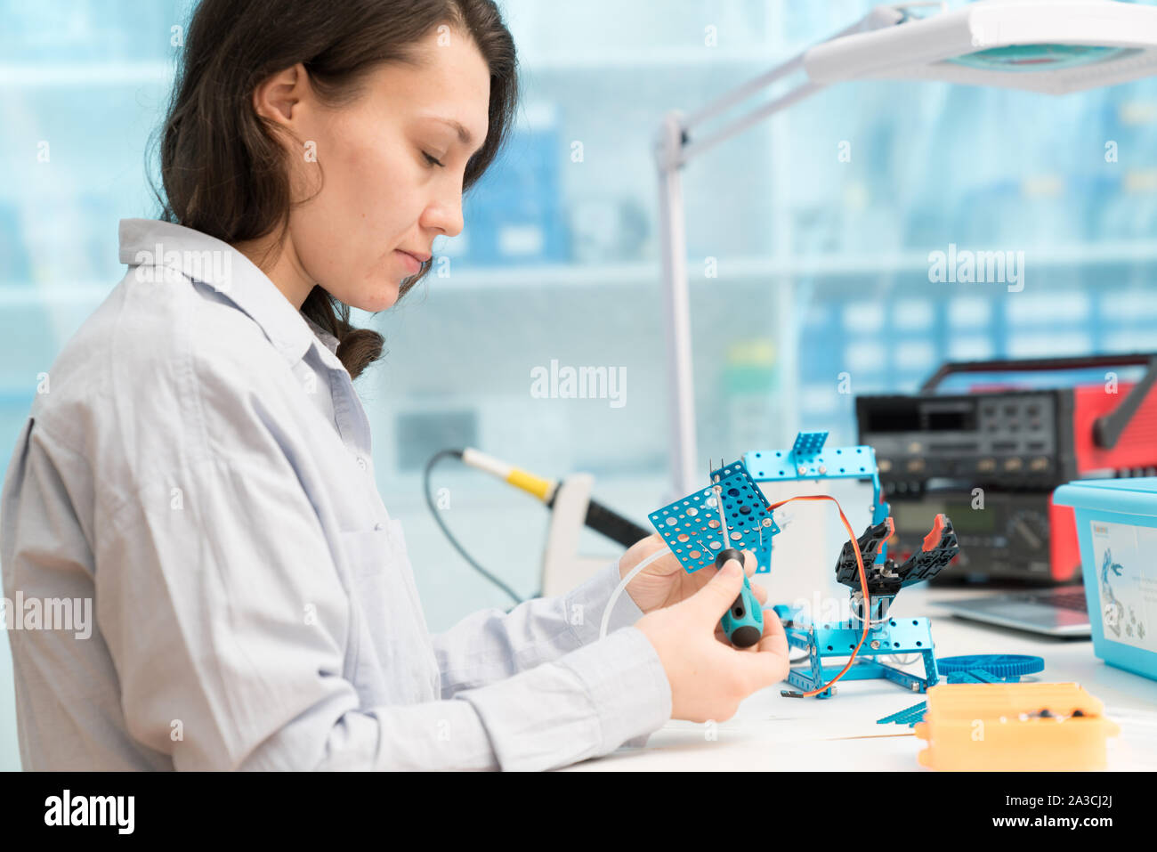 Student woman in robotics laboratory working on project mechatronics ...