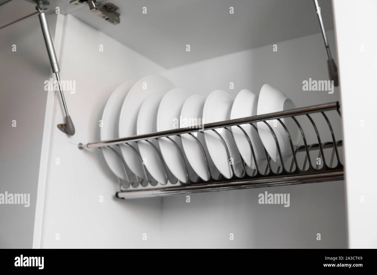 Dish drying metal rack with big nice white clean plates. Traditional ...