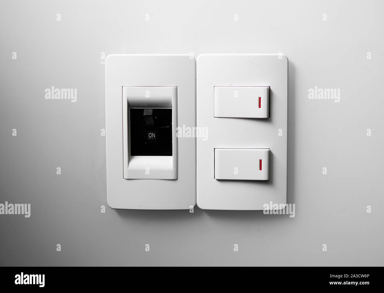White switch on a white wall with two switches and one common switch ...