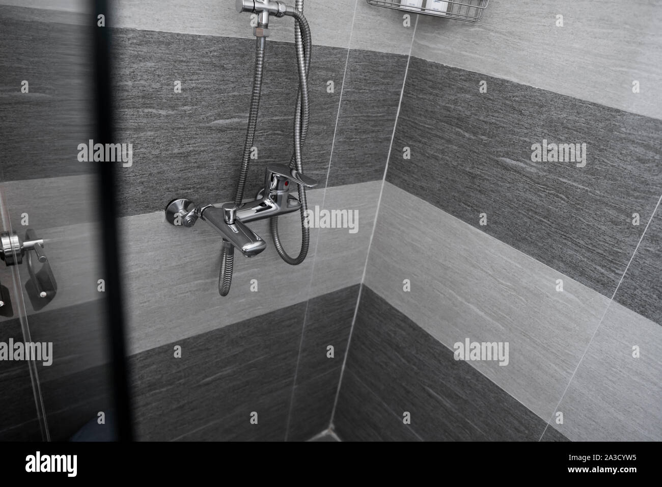 Modern designer tap and shower in bathroom. Closeup of chrome shower ...