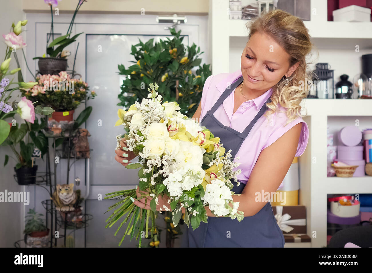 Working in flower shop. Professional florist is creating huge beautiful ...