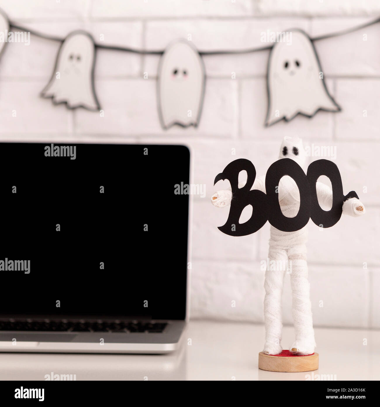 Laptop with blank screen and ghost holding boo text Stock Photo - Alamy