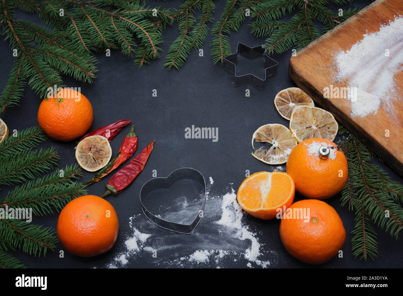 Spices flour orange food pine tree branchon a black board winter ...