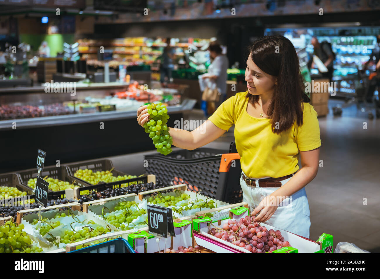 woman buying grapes in store Stock Photo - Alamy
