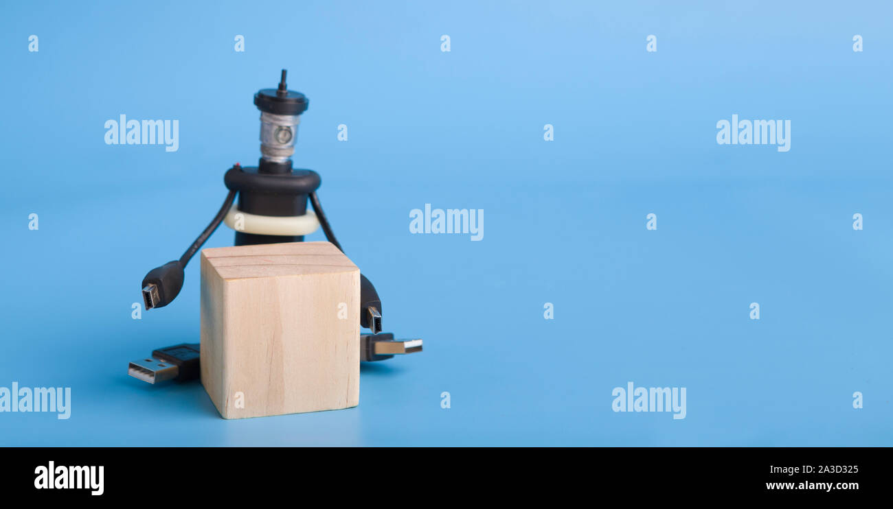 Handmade cable robot with wooden cube, blue background Stock Photo - Alamy