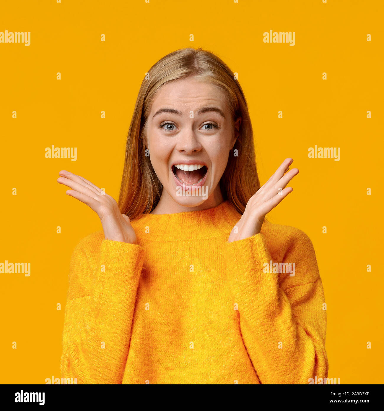 Portrait of amazed teenage girl over orange studio background Stock ...