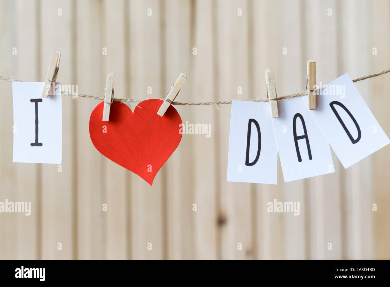 Fathers day message with paper heart hanging with pins over light ...