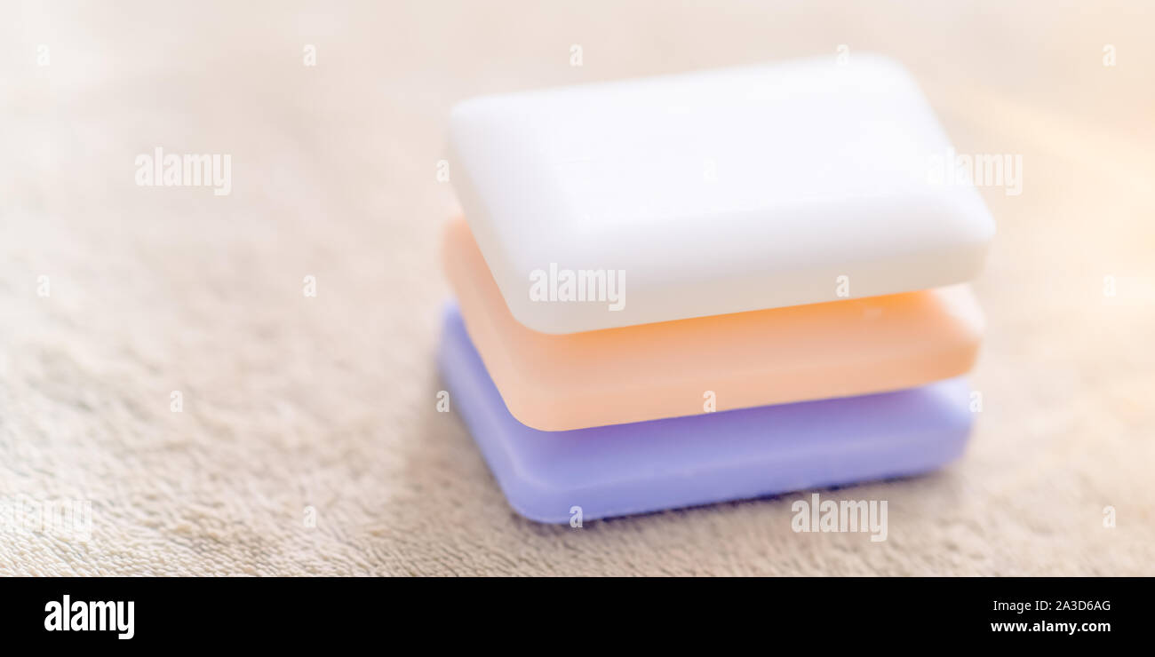 Three hard bars of soap on a pale brown towel. Side view. Copy space ...
