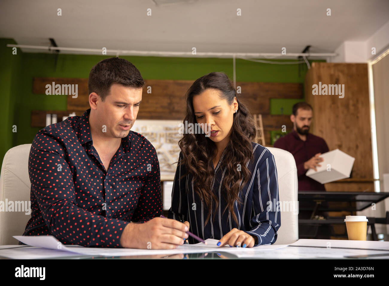 Three architects who all work on the same project in a modern office ...