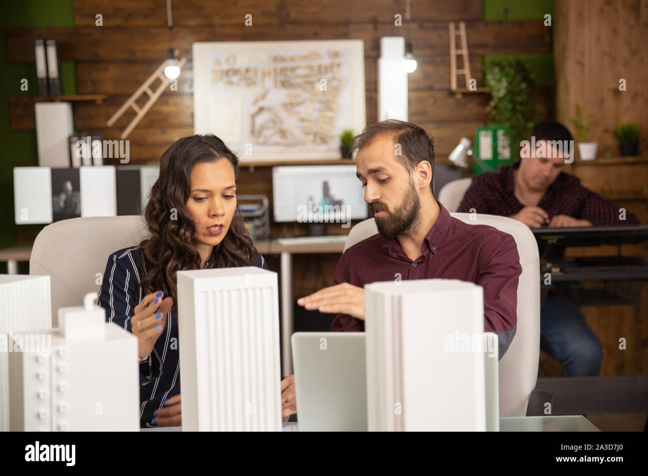 Team of creative architects working on 3D printed models of buildings ...