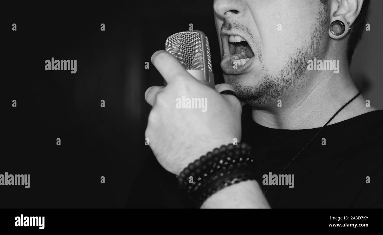 Man screaming on the microphone. Singing heavy metal. Close-up on a man ...