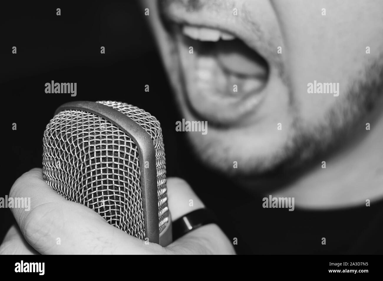 Man screaming on the microphone. Singing heavy metal. Close-up on a man ...