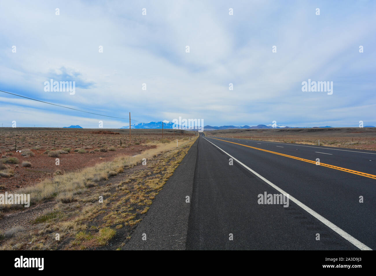 Straight road running in the desert with a panoramic mountain view ...