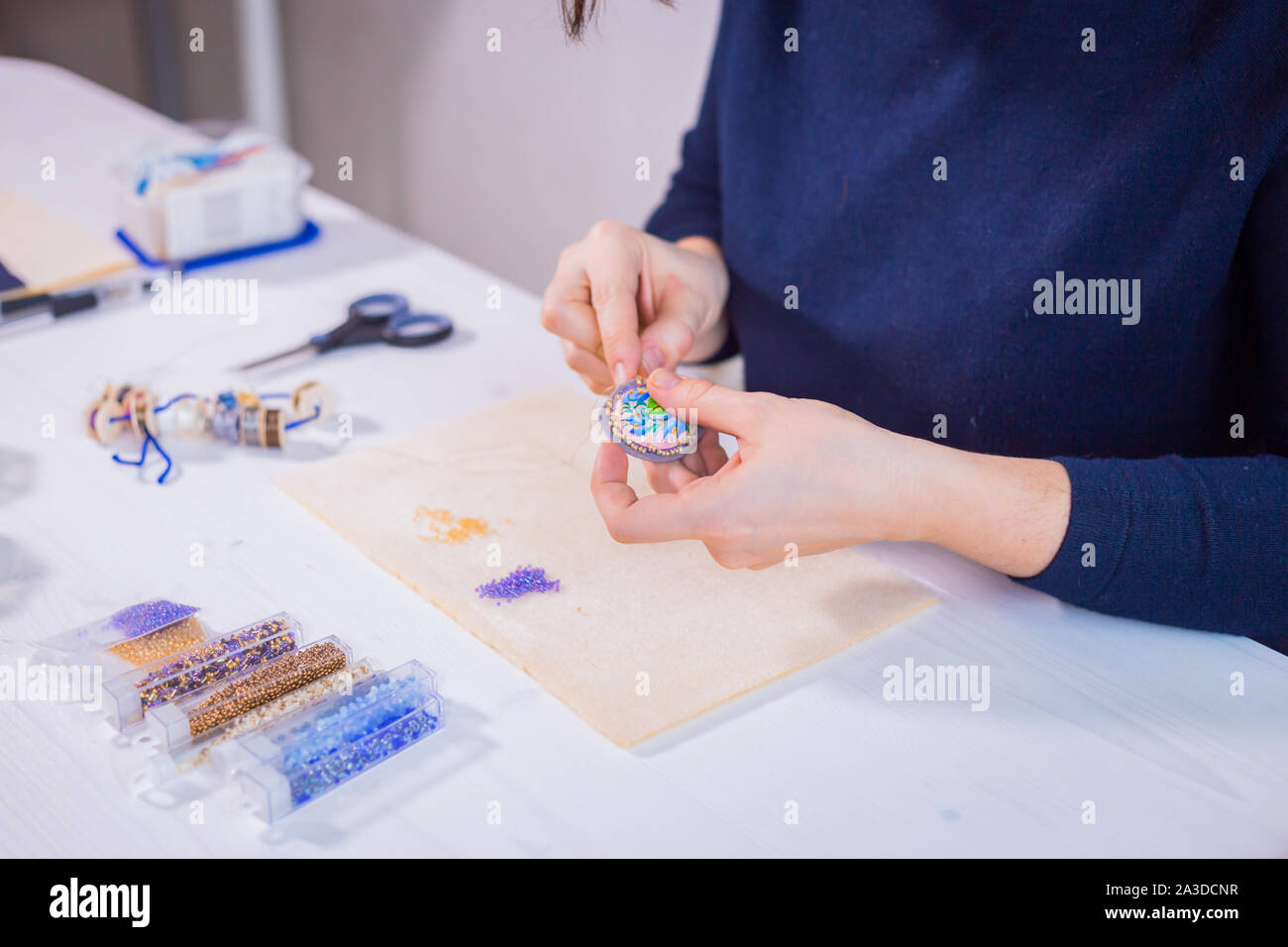 Designer making handmade brooch Stock Photo - Alamy