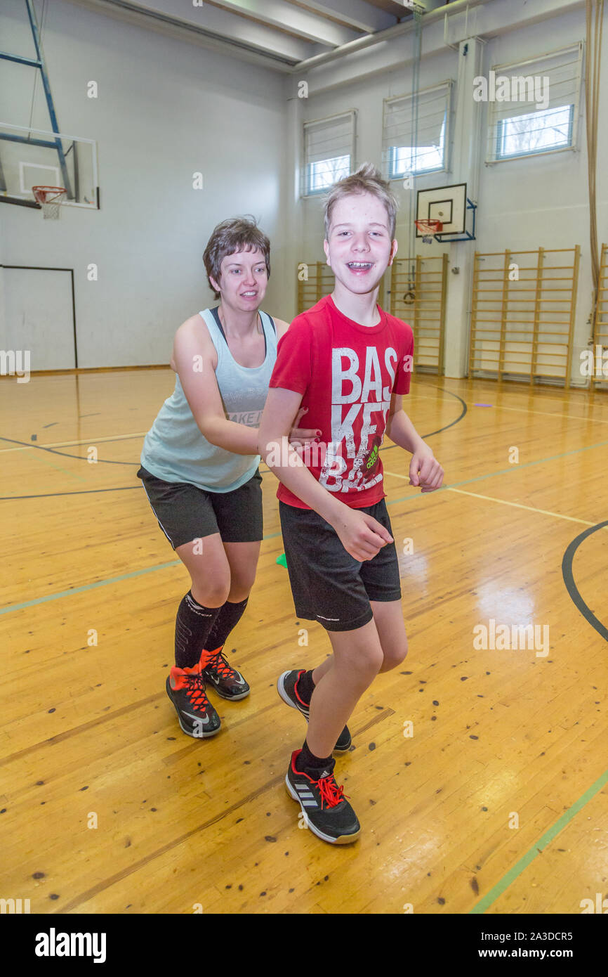 Group of disabled down syndrome men and women doing sports at indoor ...