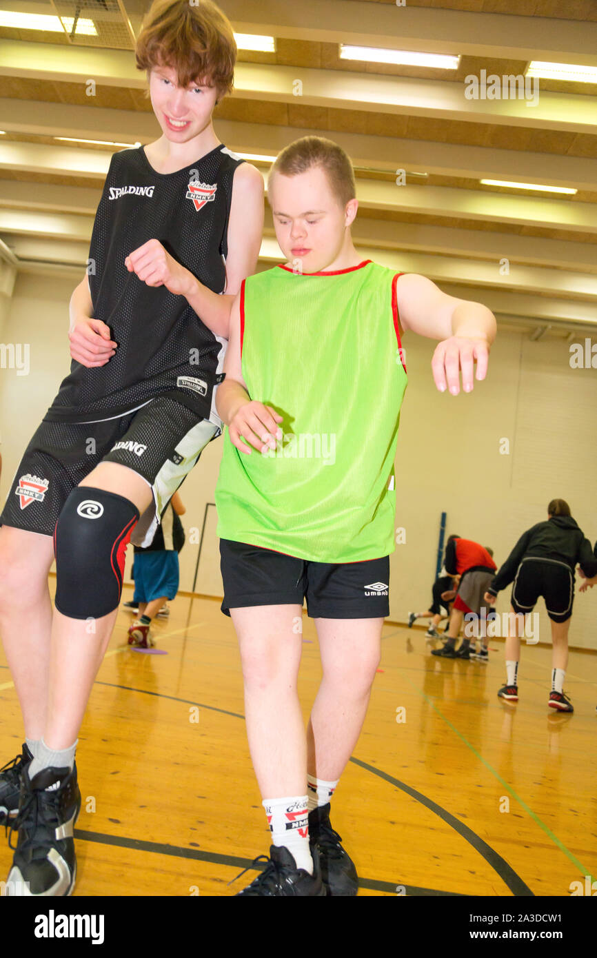Group of disabled down syndrome men and women doing sports at indoor ...