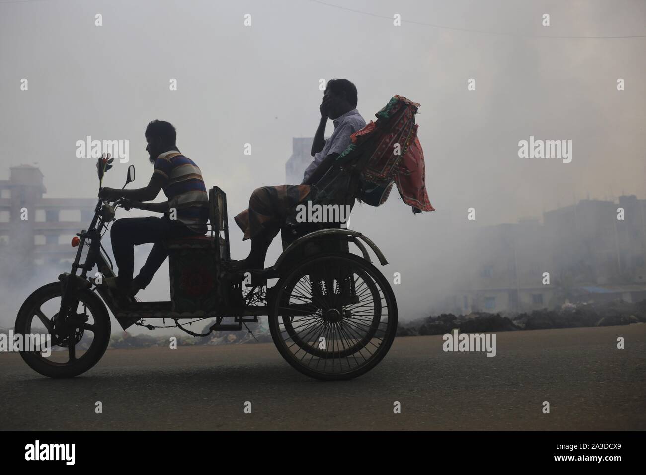 Dhaka, Bangladesh. 7th Oct, 2019. An auto rickshaw passenger holds nose ...