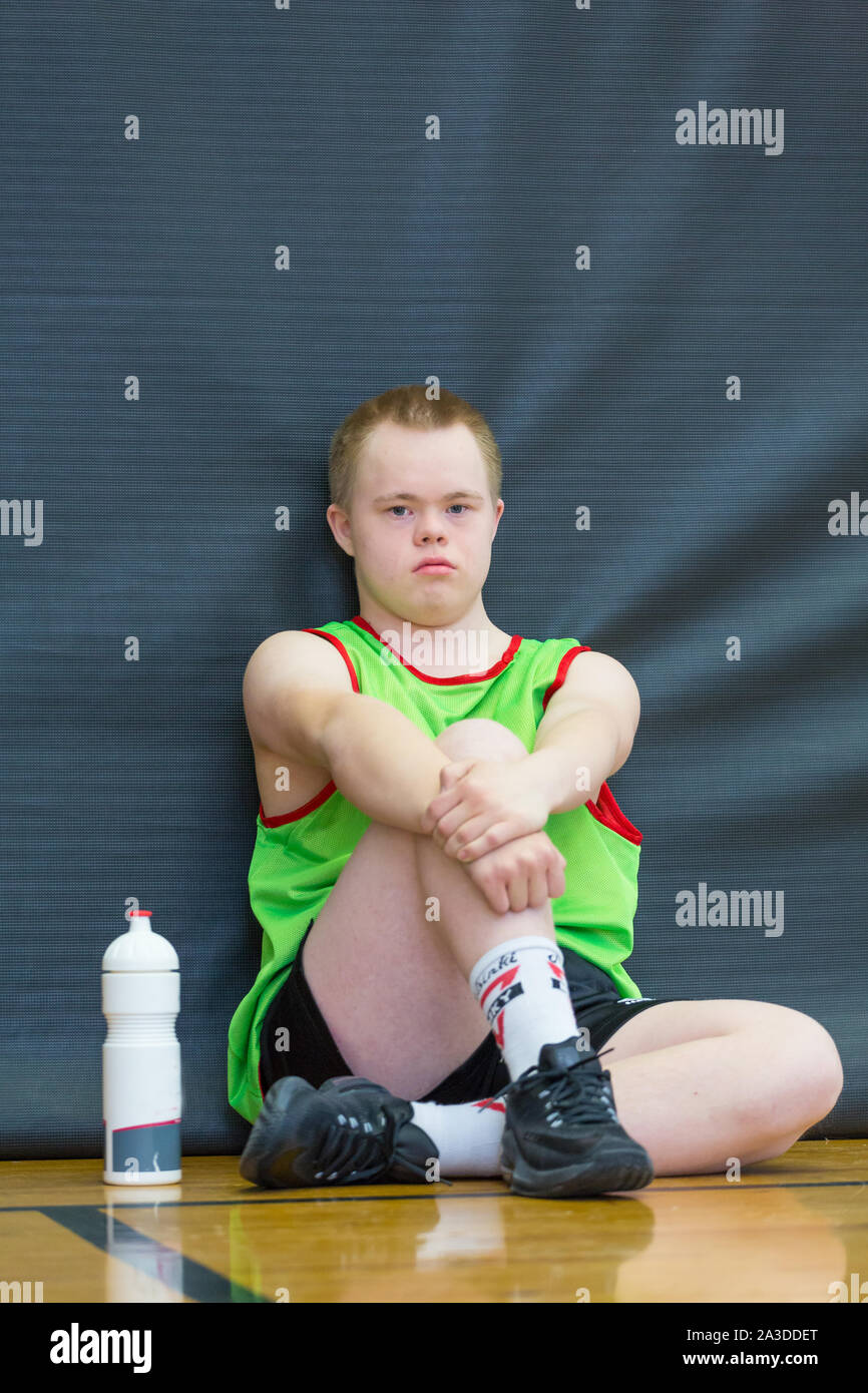 Group of disabled down syndrome men and women doing sports at indoor ...