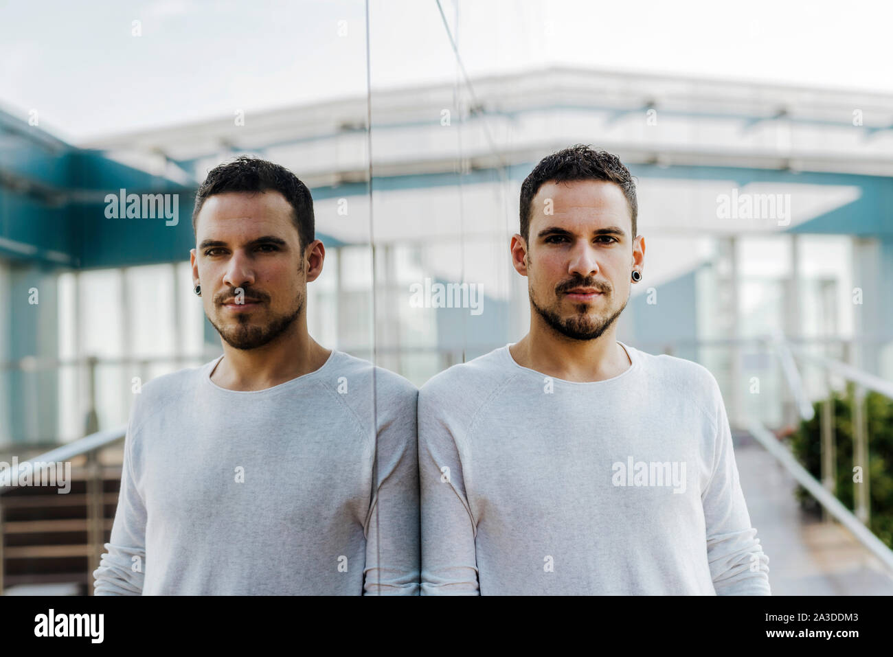One attractive man leaning on glass shop window looking at camera Stock ...