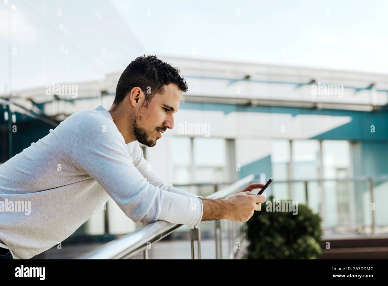 Leaning railing browsing mobile phone hi-res stock photography and ...