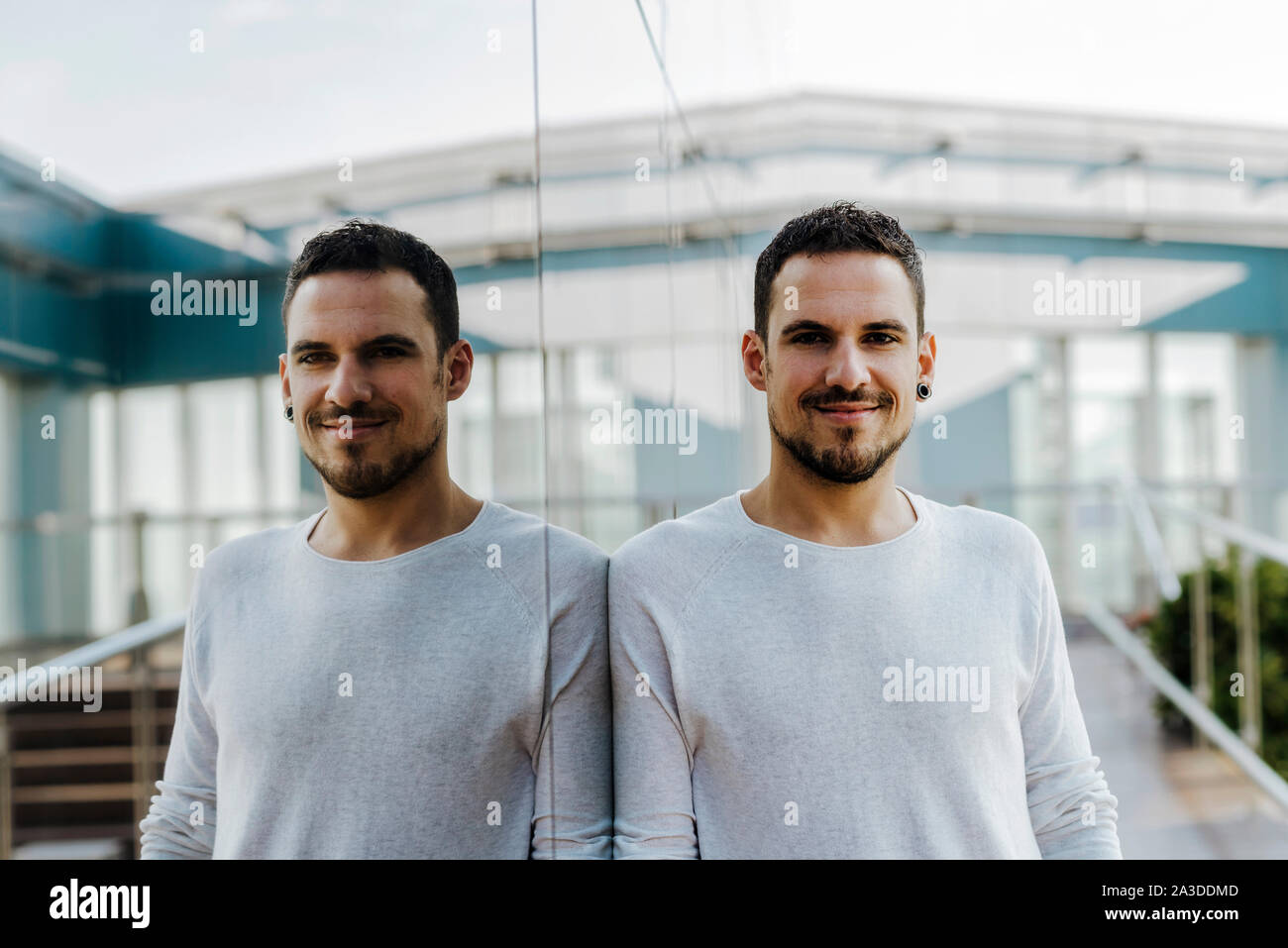 One attractive man leaning on glass shop window looking at camera Stock ...