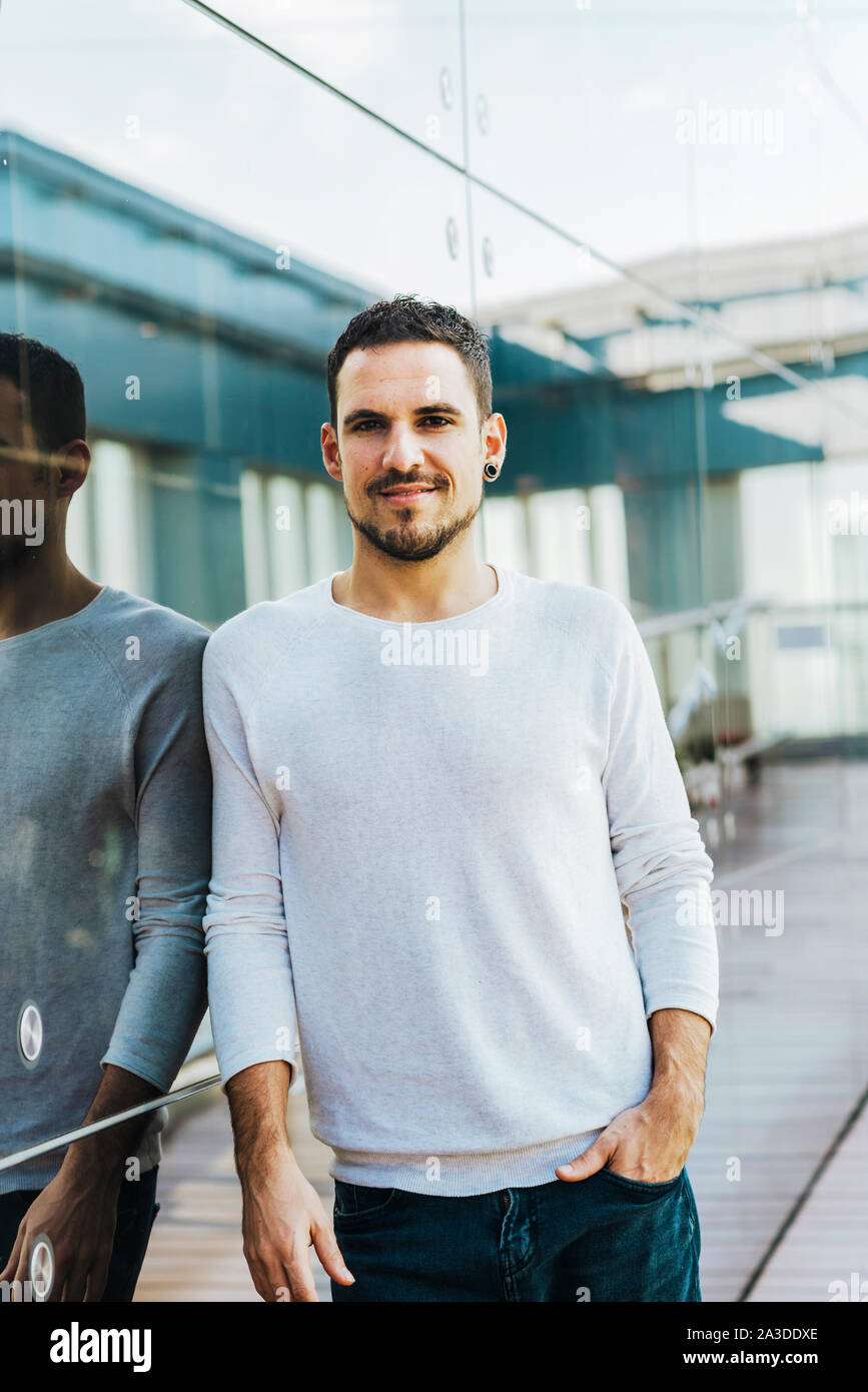 One attractive man leaning on glass shop window looking at camera Stock ...