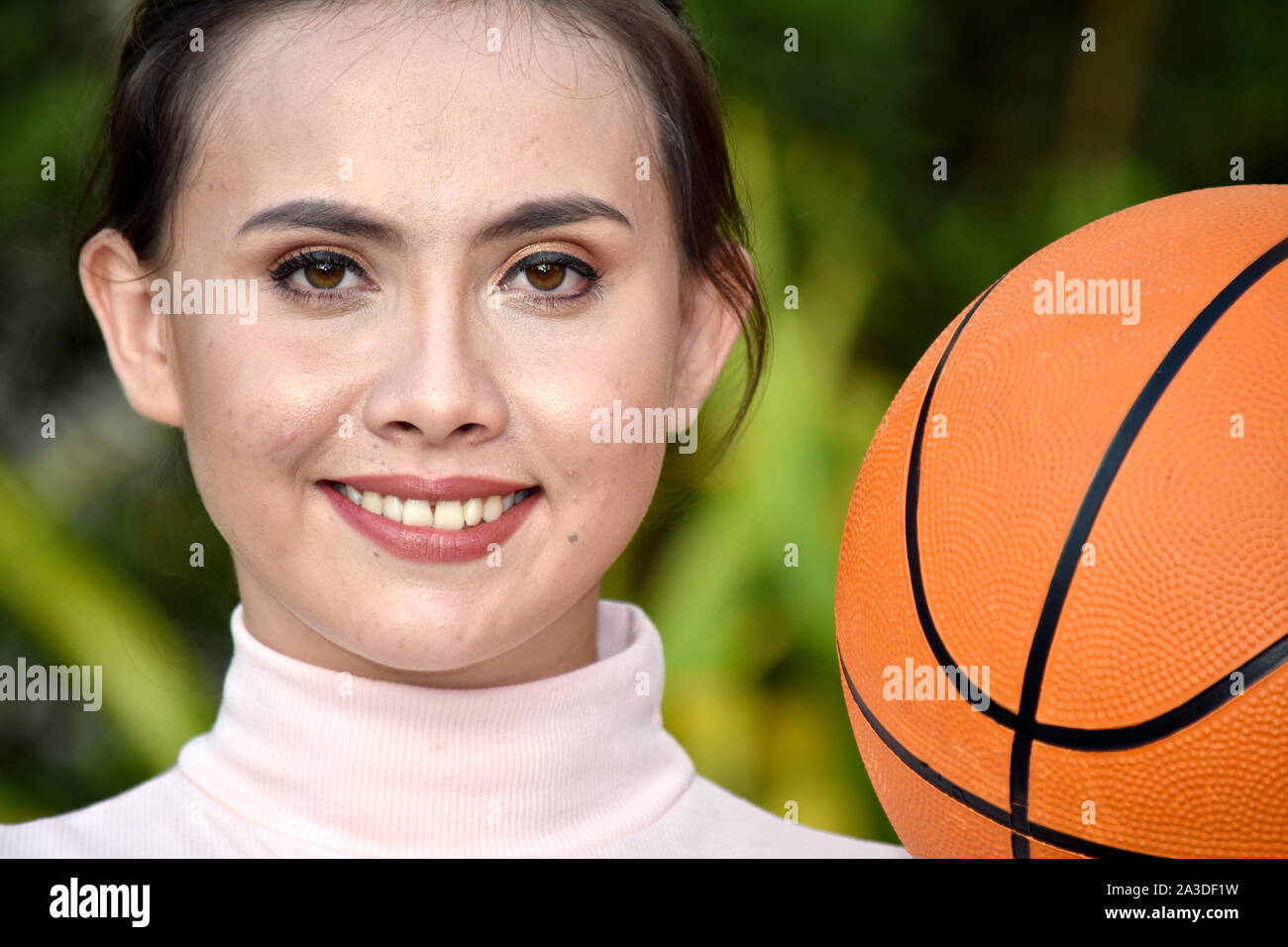 Pretty Female Basketball Player Smiling With Basketball Stock Photo - Alamy