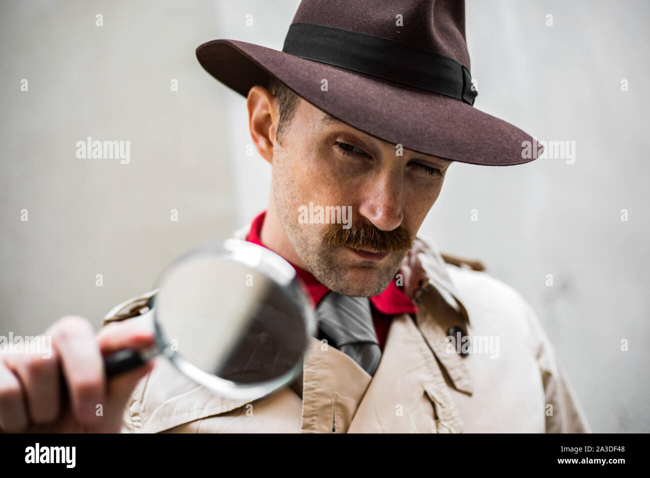 Detective using a magnify lens Stock Photo - Alamy